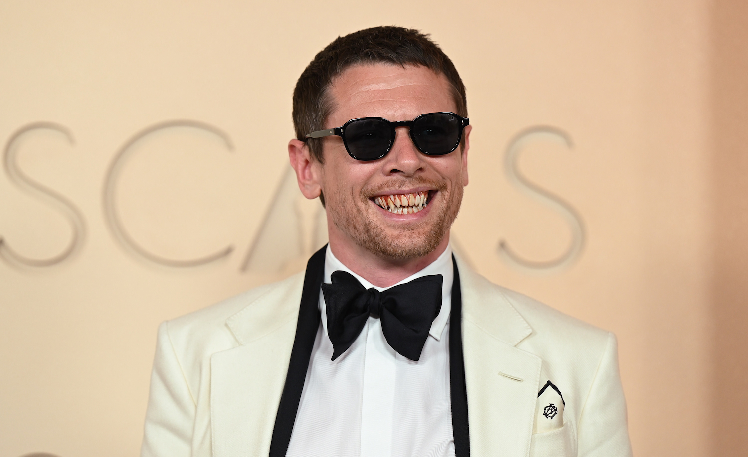 Actor Flashes Vampire Fangs on Oscars Red Carpet - PopCulture.com